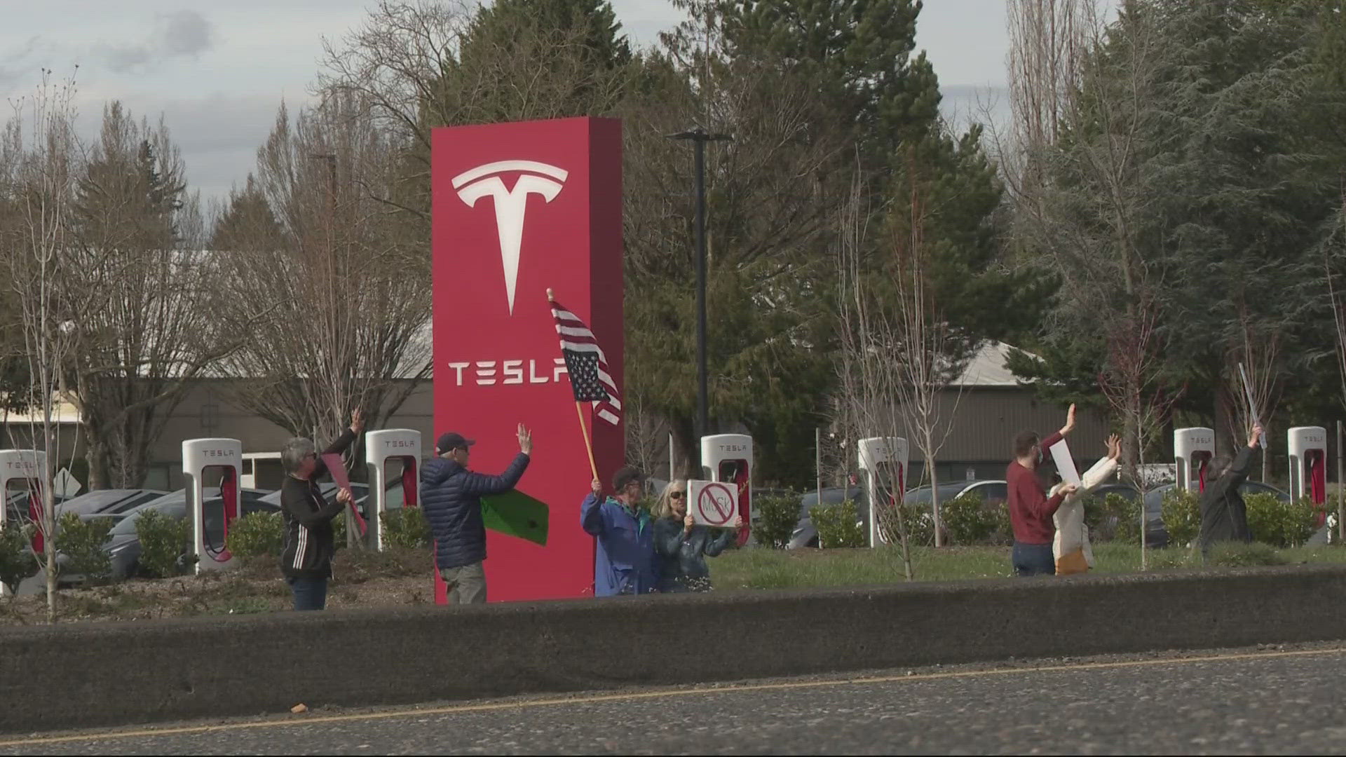 Protesters rally against Elon Musk outside Vancouver Tesla store | kgw.com
